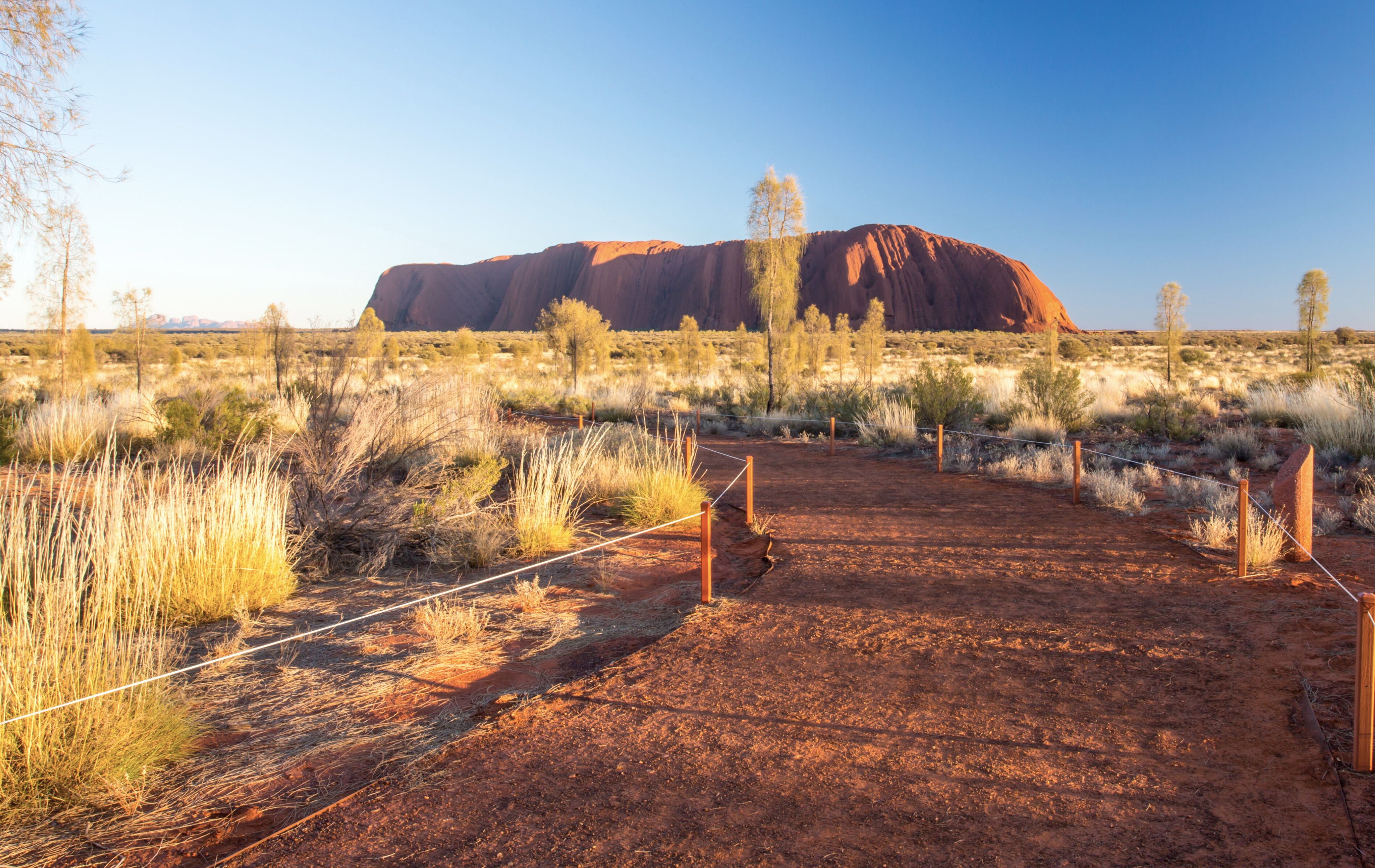 The red hues of Uluru, an awe-inspiring natural monolith that is both ...